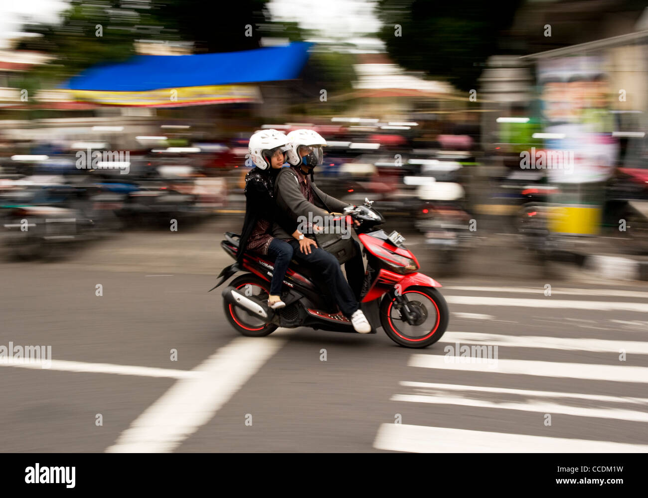 A moped rider carries a passenger along Jalan Malioboro, central ...
