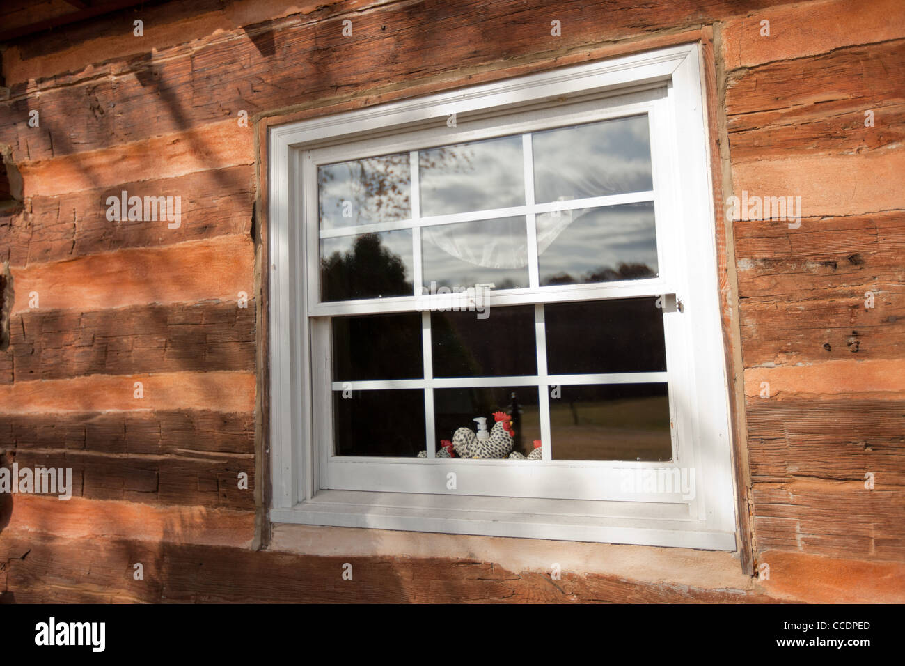 A kitchen window on the side of an old log cabin in rural North ...