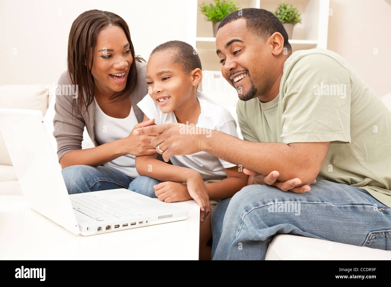 African American family, parents and son, having fun using a laptop ...
