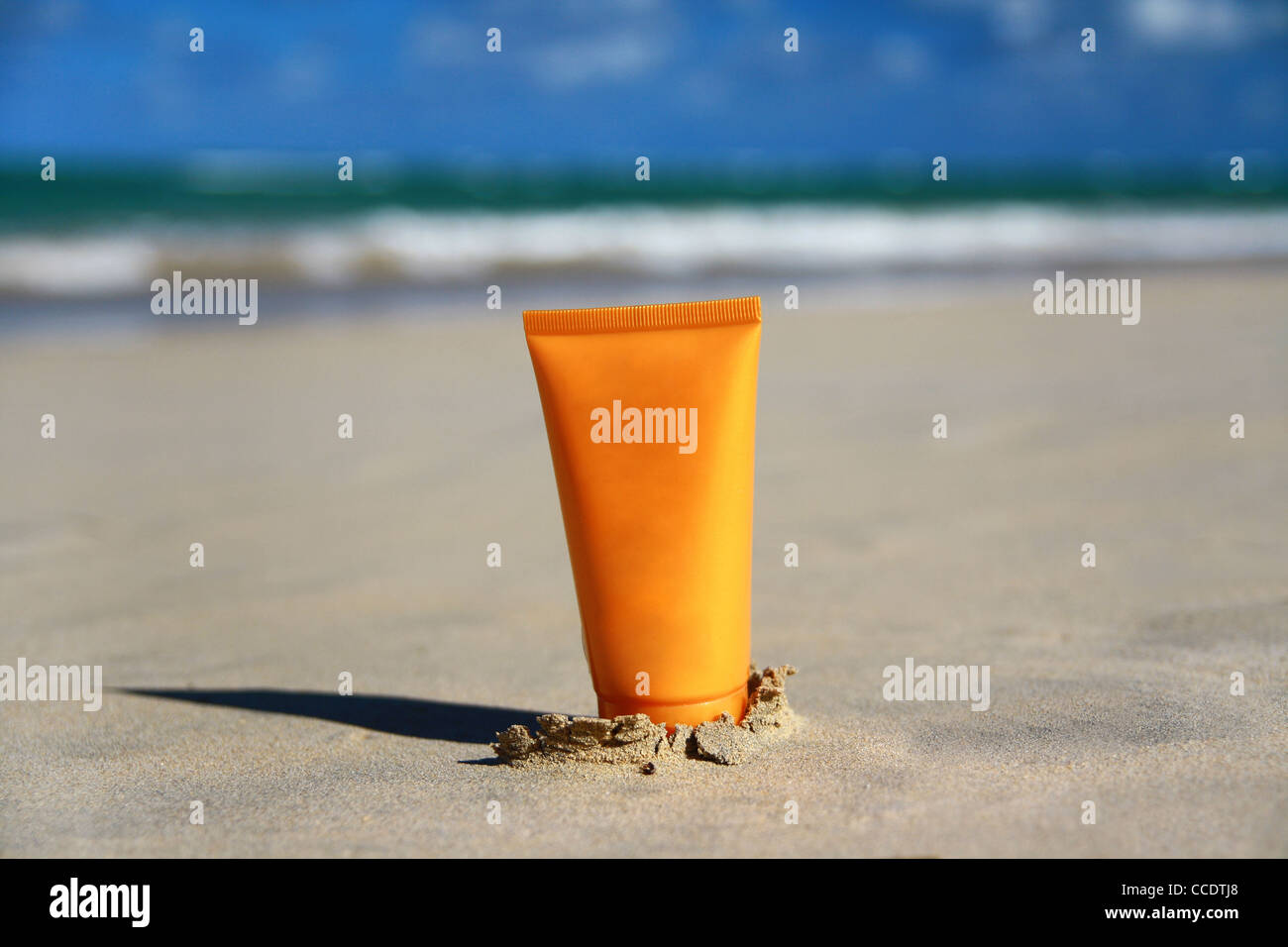Tube with sun protection on beach of ocean Stock Photo - Alamy