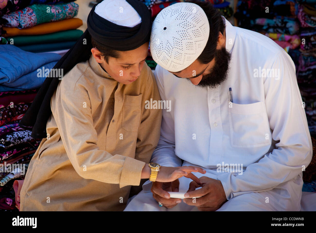Muslim man and boy using a smartphone, Murree, Punjab Province ...