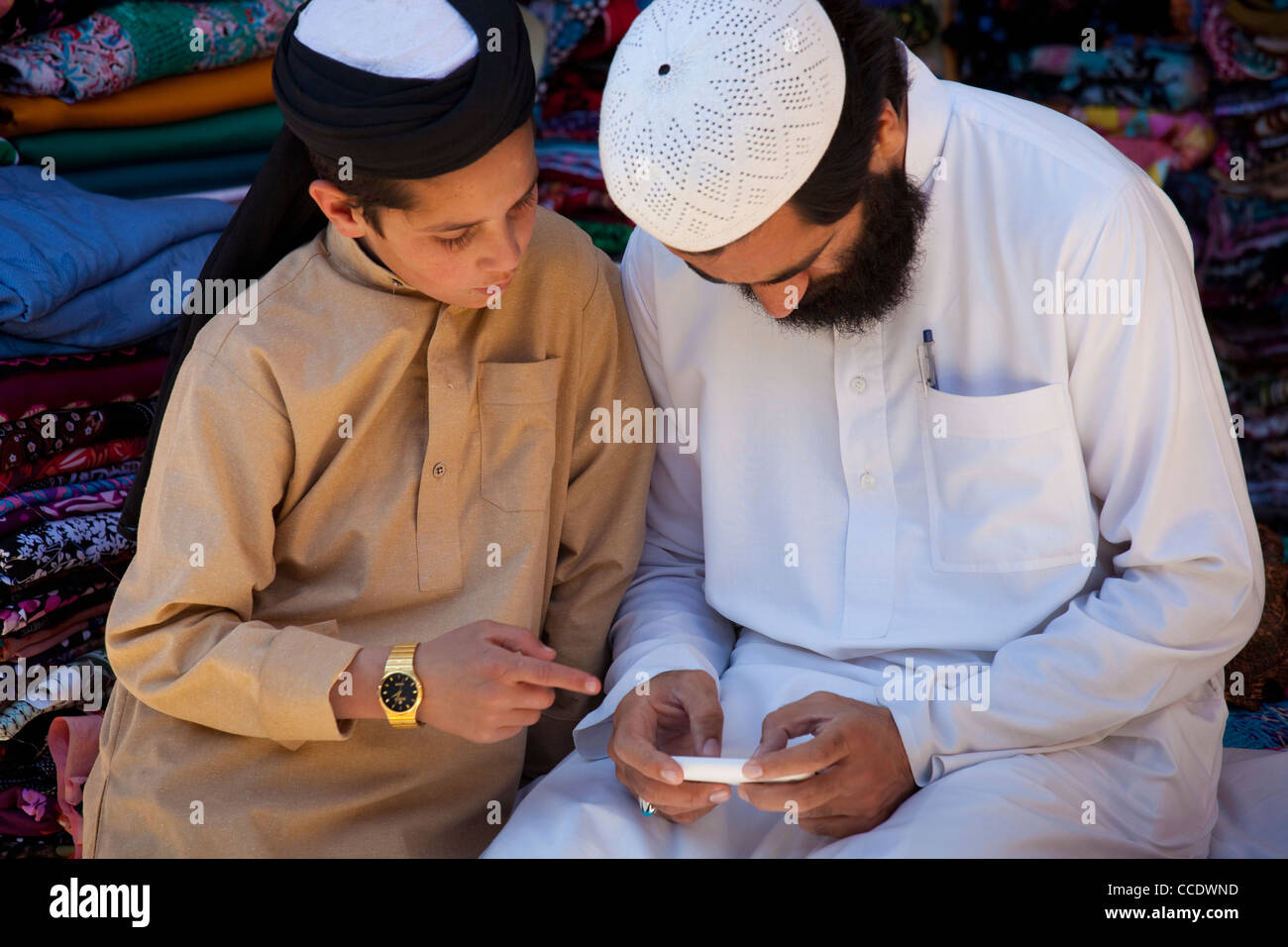 Muslim man and boy using a smartphone, Murree, Punjab Province ...