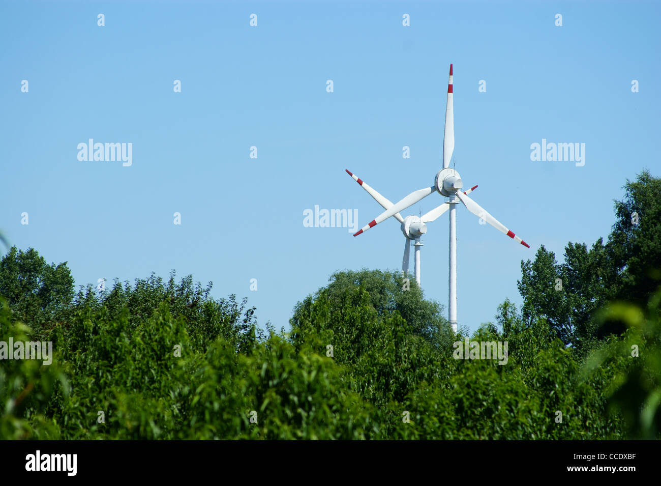 Wind power turbine, forest - blue sky Stock Photo - Alamy