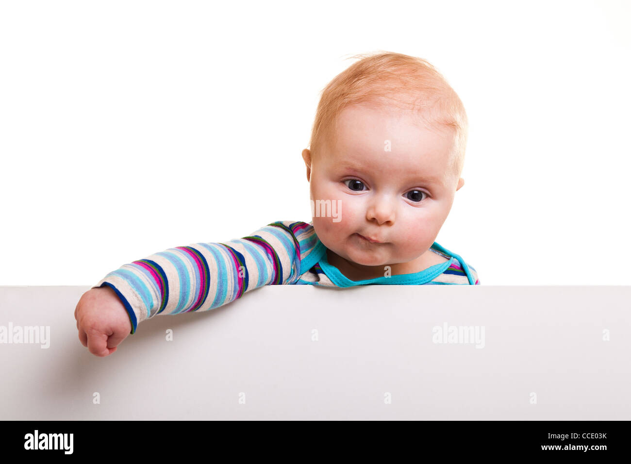 Infant baby behind whiteboard with lot of copyspace for advertisement ...