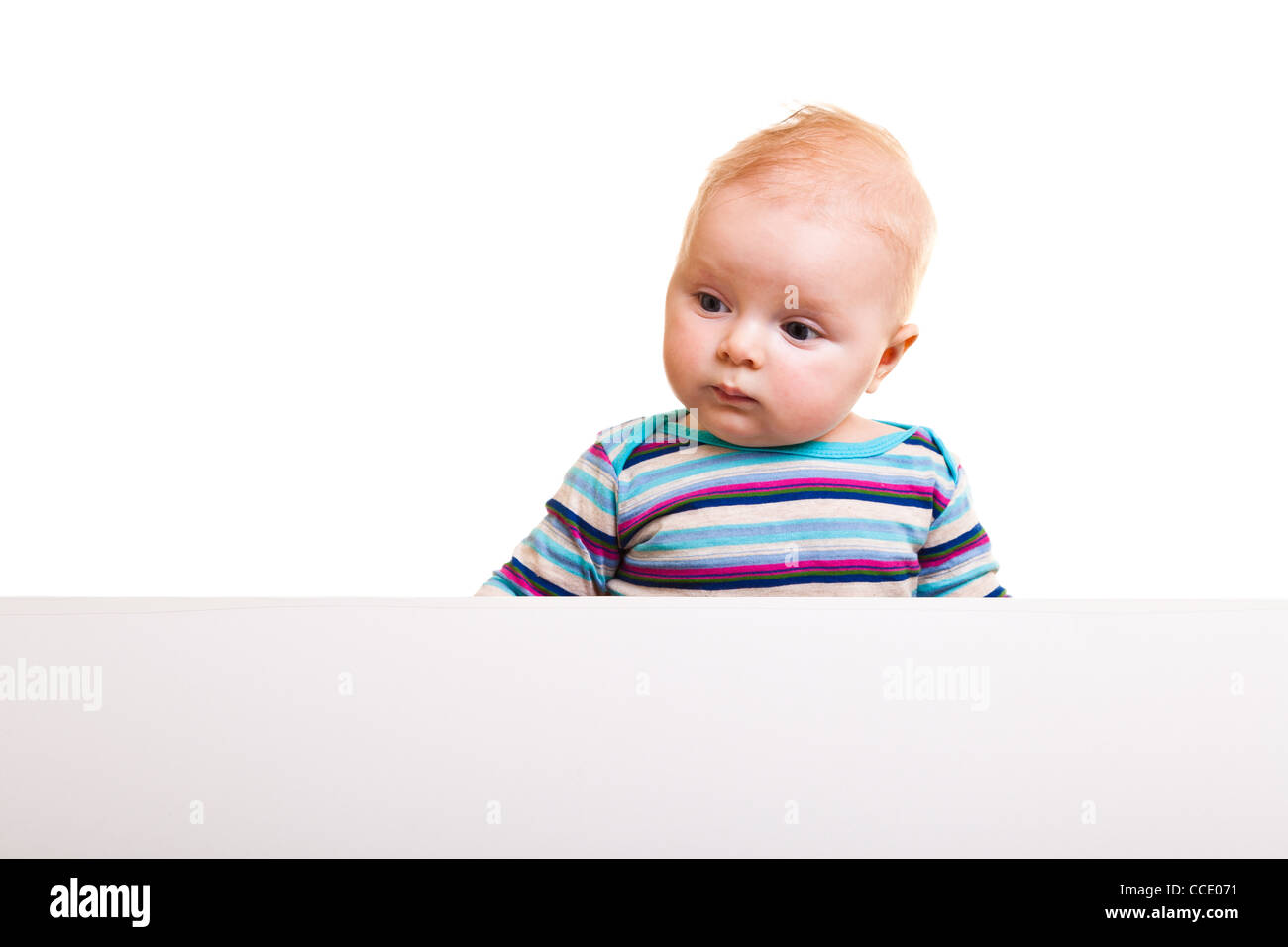 Infant baby behind whiteboard with lot of copyspace for advertisement ...