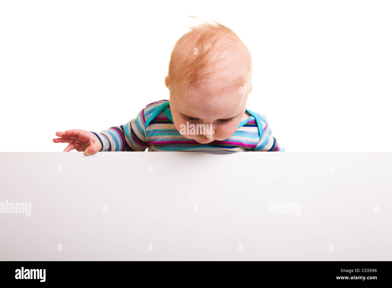 Infant baby behind whiteboard with lot of copyspace for advertisement ...