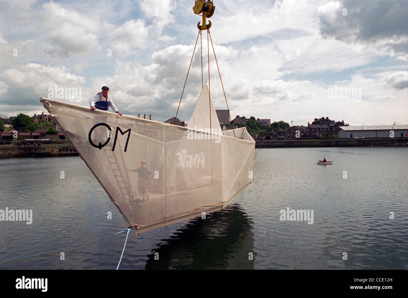 Sculptor George Wyllie's (on bow) Paper boat is craned into the water ...