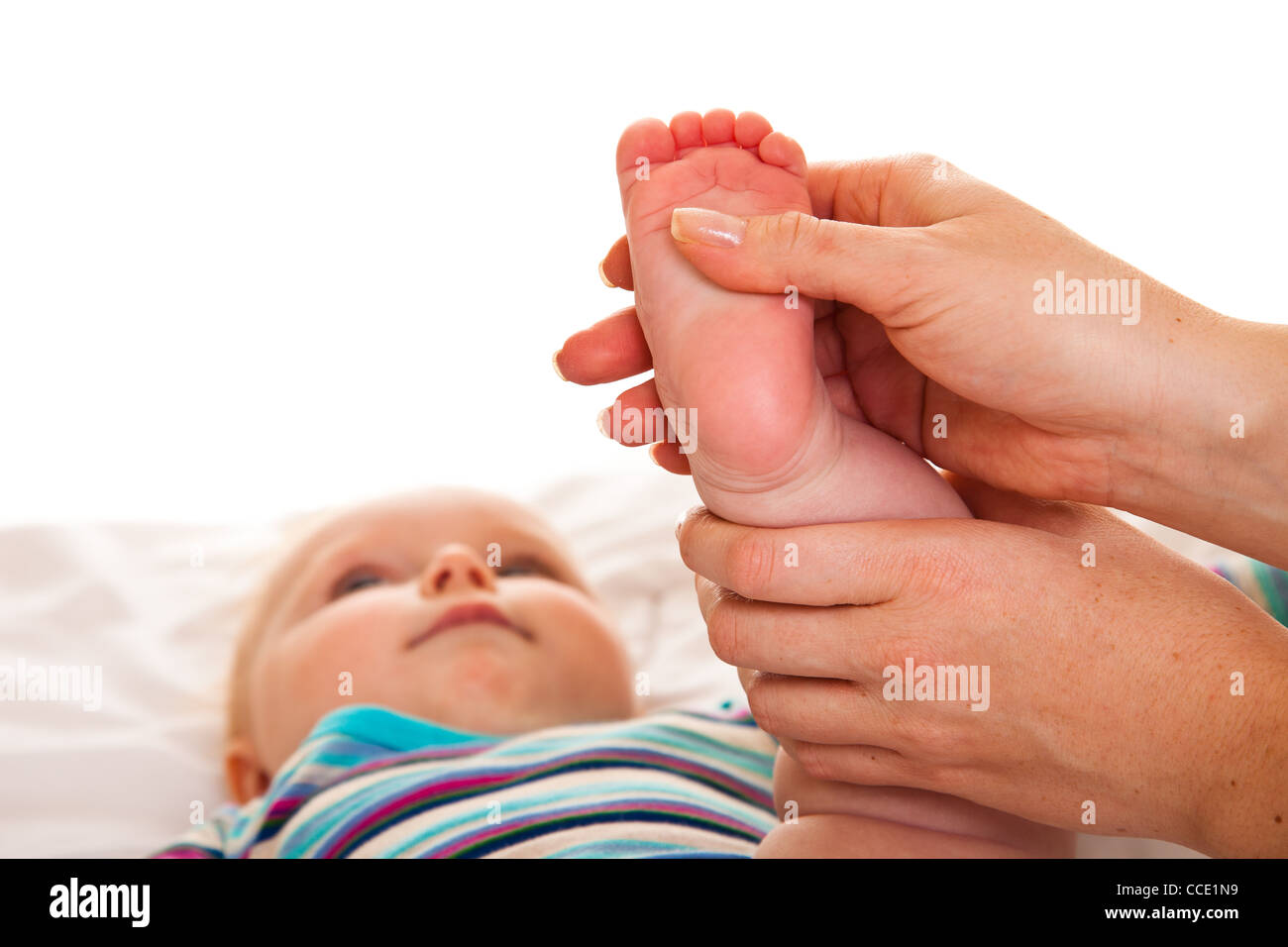 Foot massage of infant baby isolated on white Stock Photo - Alamy