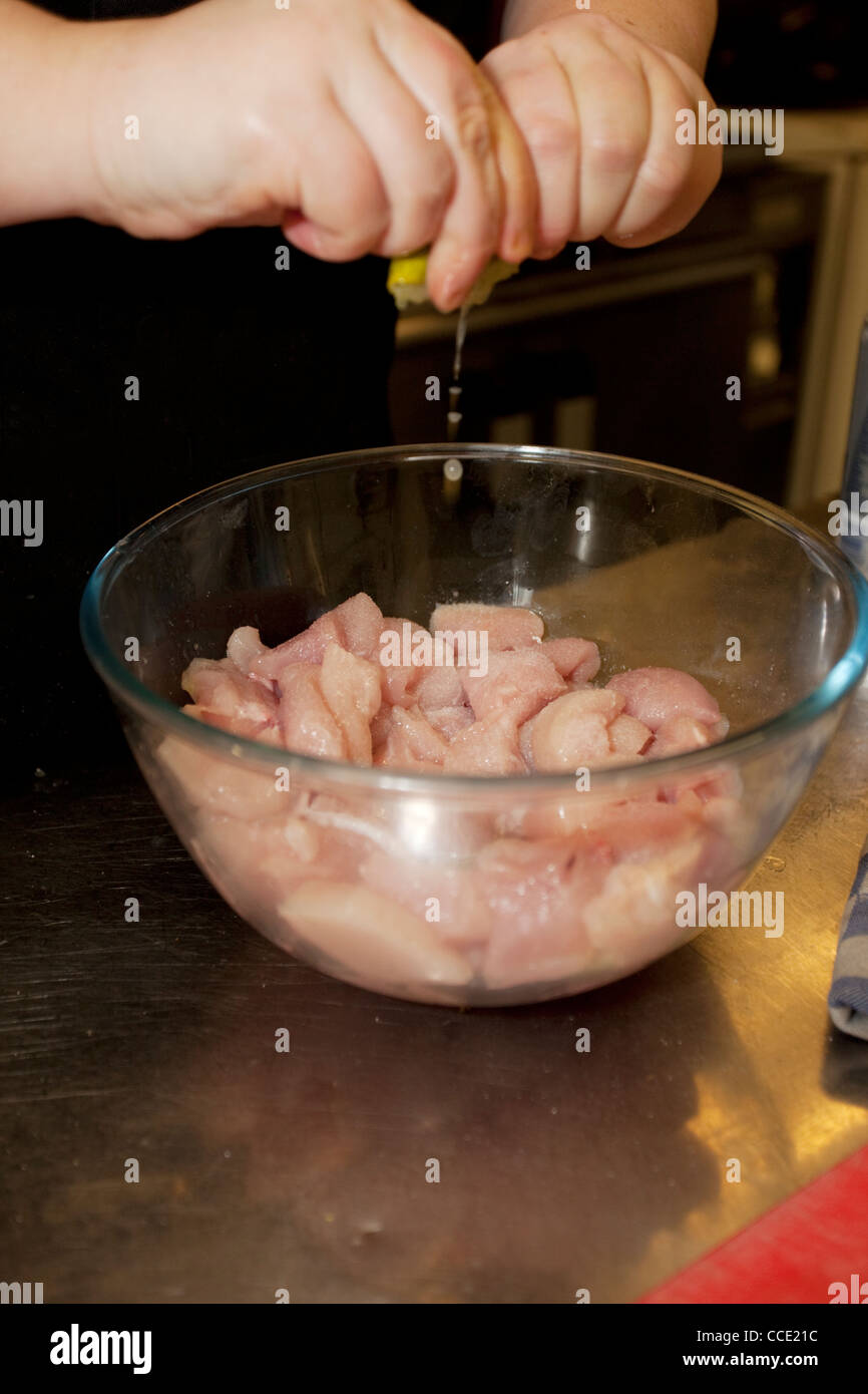 squeezing lime juice onto raw chicken pieces Stock Photo - Alamy