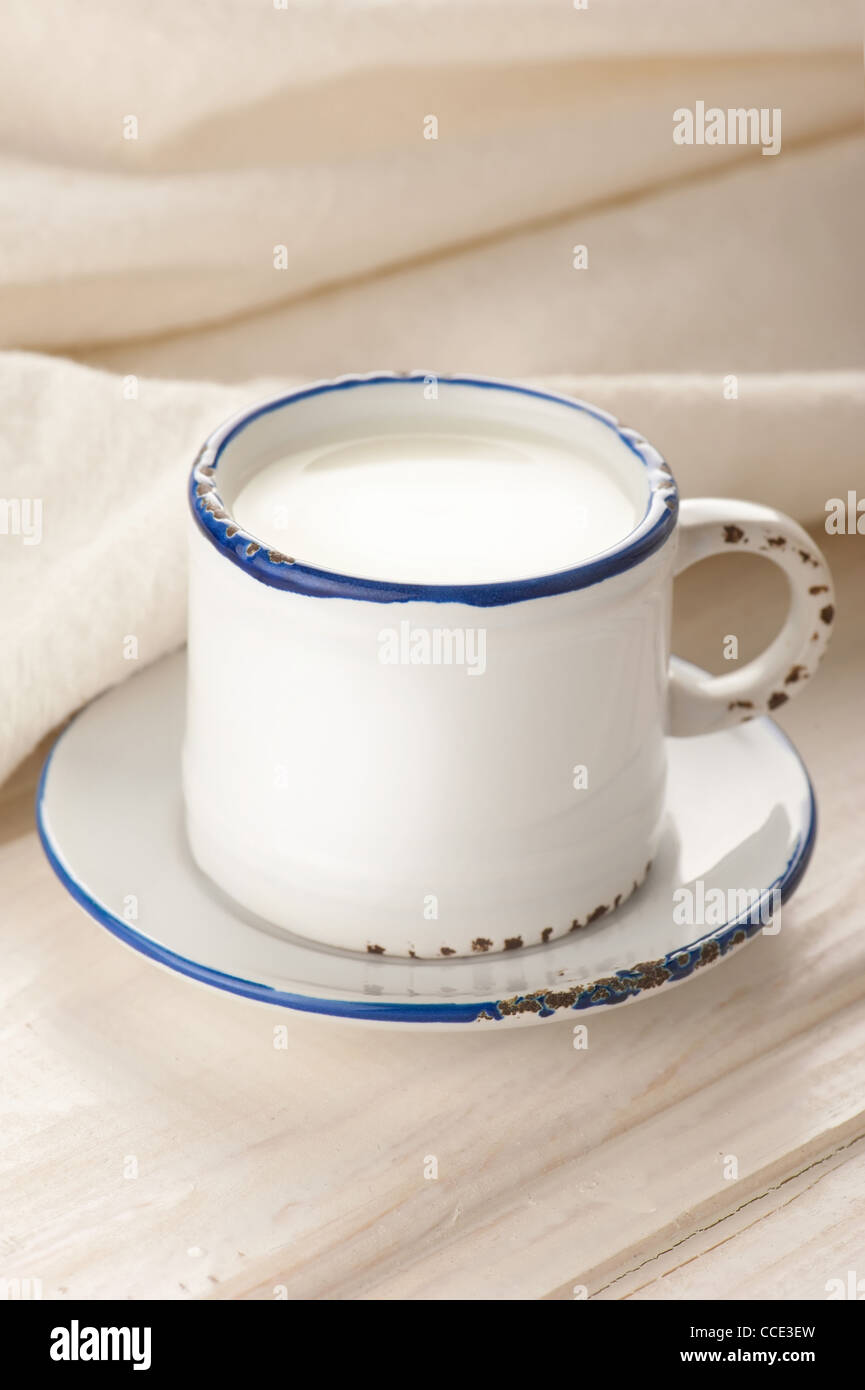 Breakfast with milk. Milk in vintage cup on old wooden table with linen ...