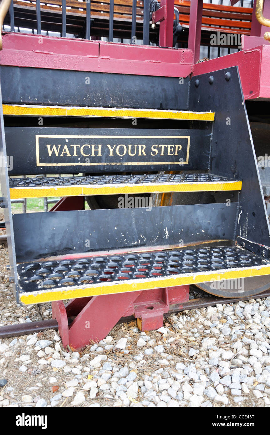 Watch your step sign on old train steps Stock Photo - Alamy