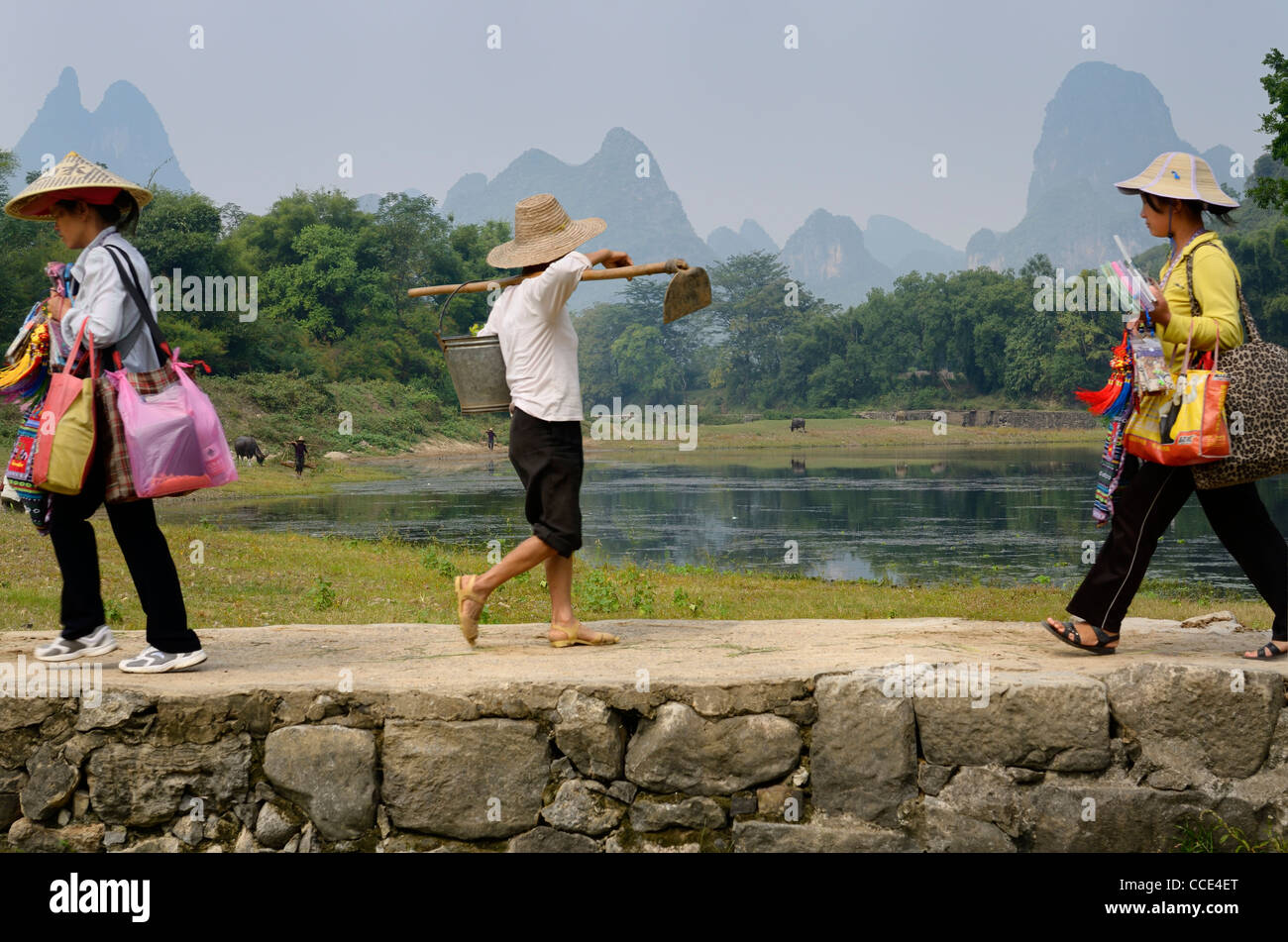 Chinese women walking on stone bridge at Fuli on the Li river inlet ...