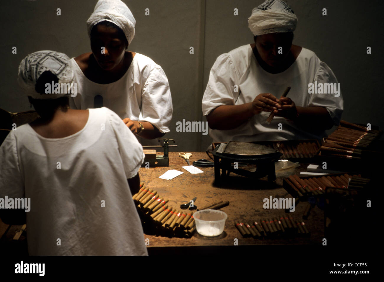 Woman in traditional costume rolls cigars at Dannemann cigar factory in ...