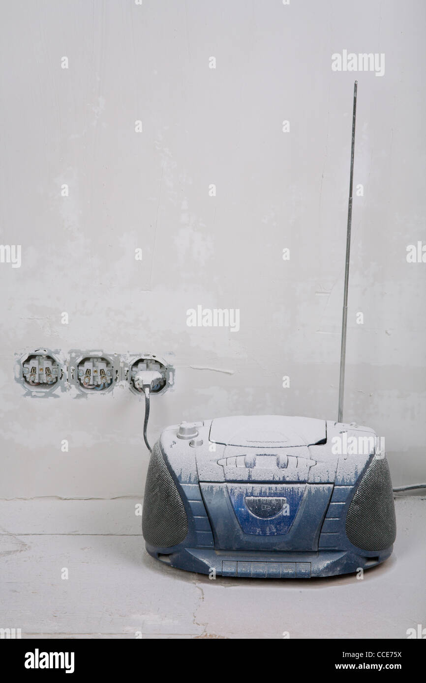 Repair of a room. A radio receiver in a dust on a background of a grey ...