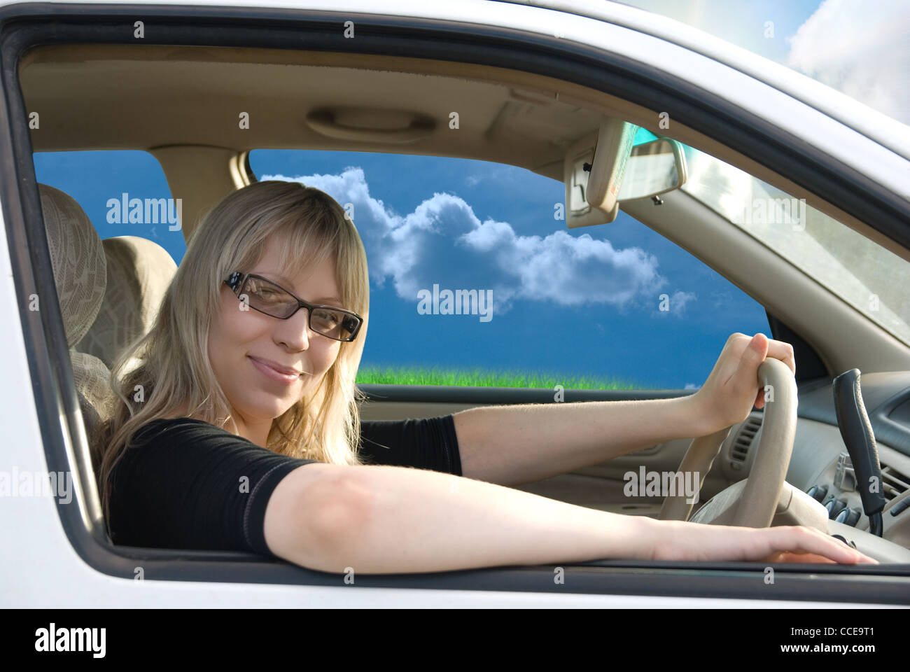 Pretty young woman driving car on nature background Stock Photo - Alamy