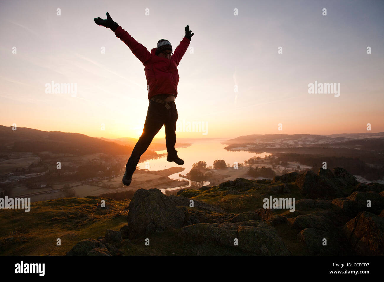 A man jumping for joy at sunrise over Lake Windermere from Todd Crag ... A man jumping for joy at sunrise over Lake Windermere from Todd Crag ...