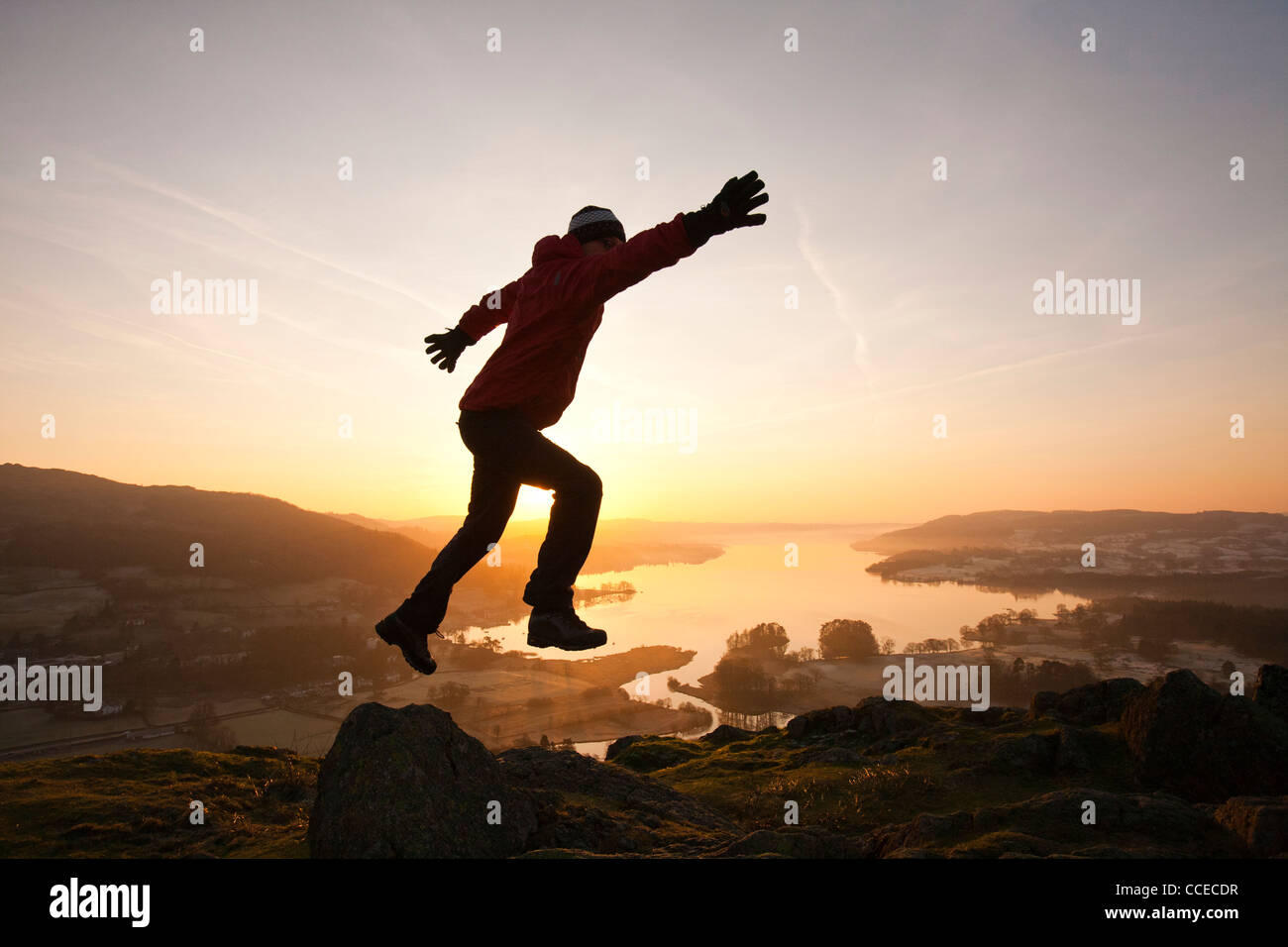 A man jumping for joy at sunrise over Lake Windermere from Todd Crag ... A man jumping for joy at sunrise over Lake Windermere from Todd Crag ...