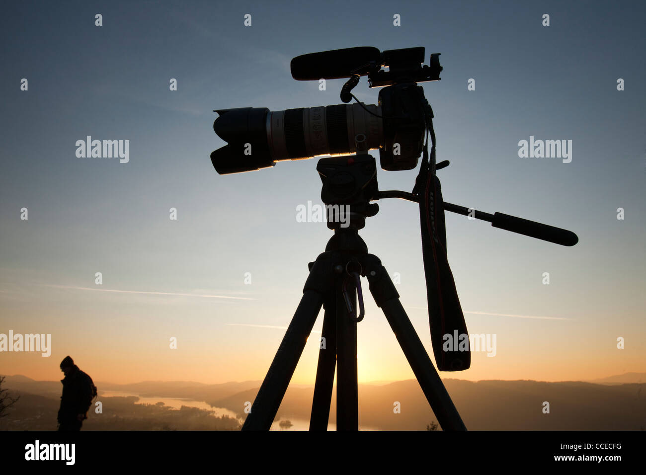 A DSLR camera on a tripod with video microphone on a tripod at sunset ...