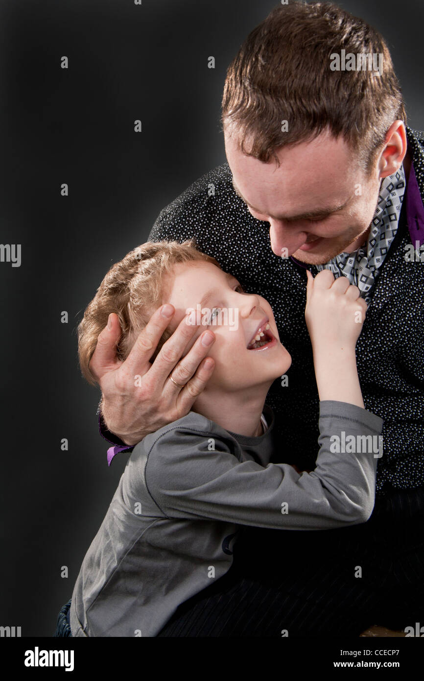Father and son cheerfully talk. On a gray background. Boy not in focus ...