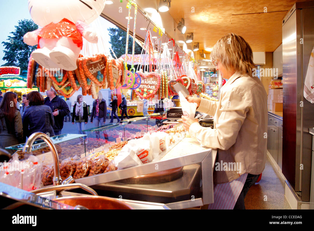 female seller filling paper bag with almonds at german mobile sales ...