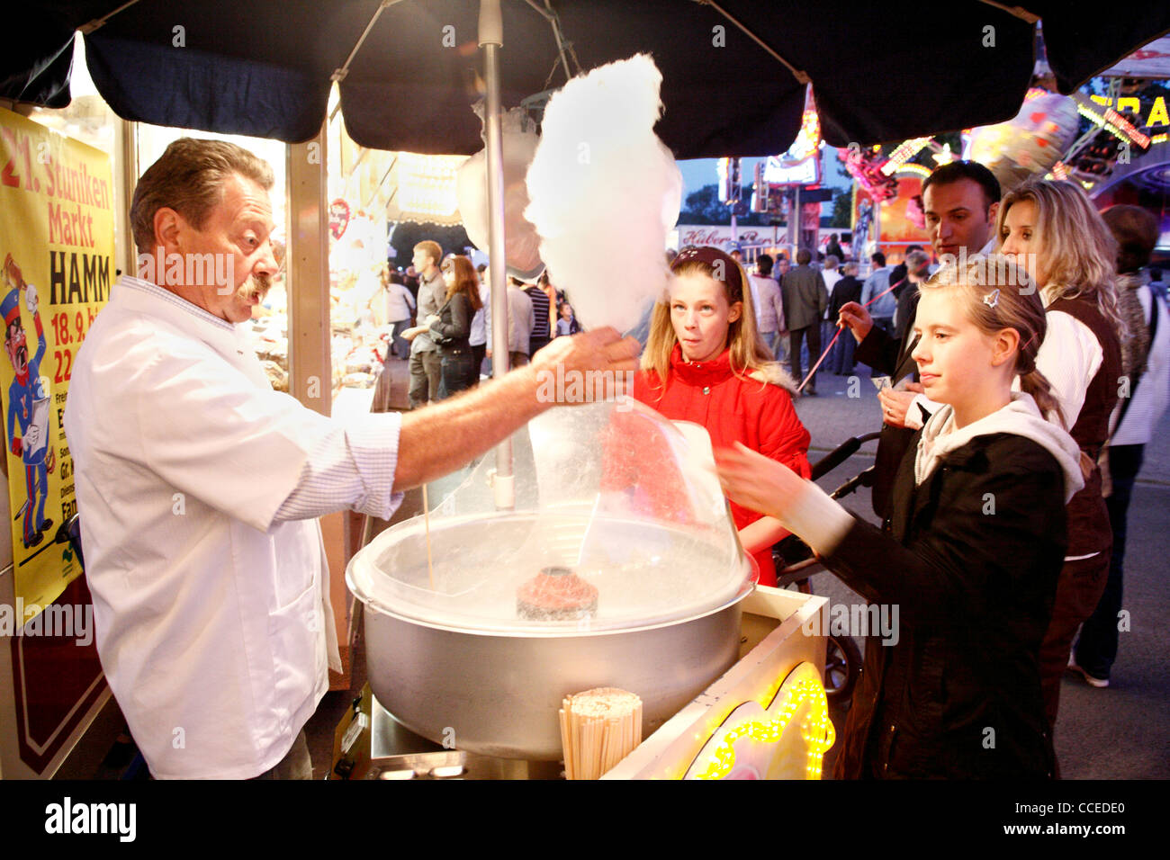 two girls infront of german mobile sales booth at fair buying cotton ...