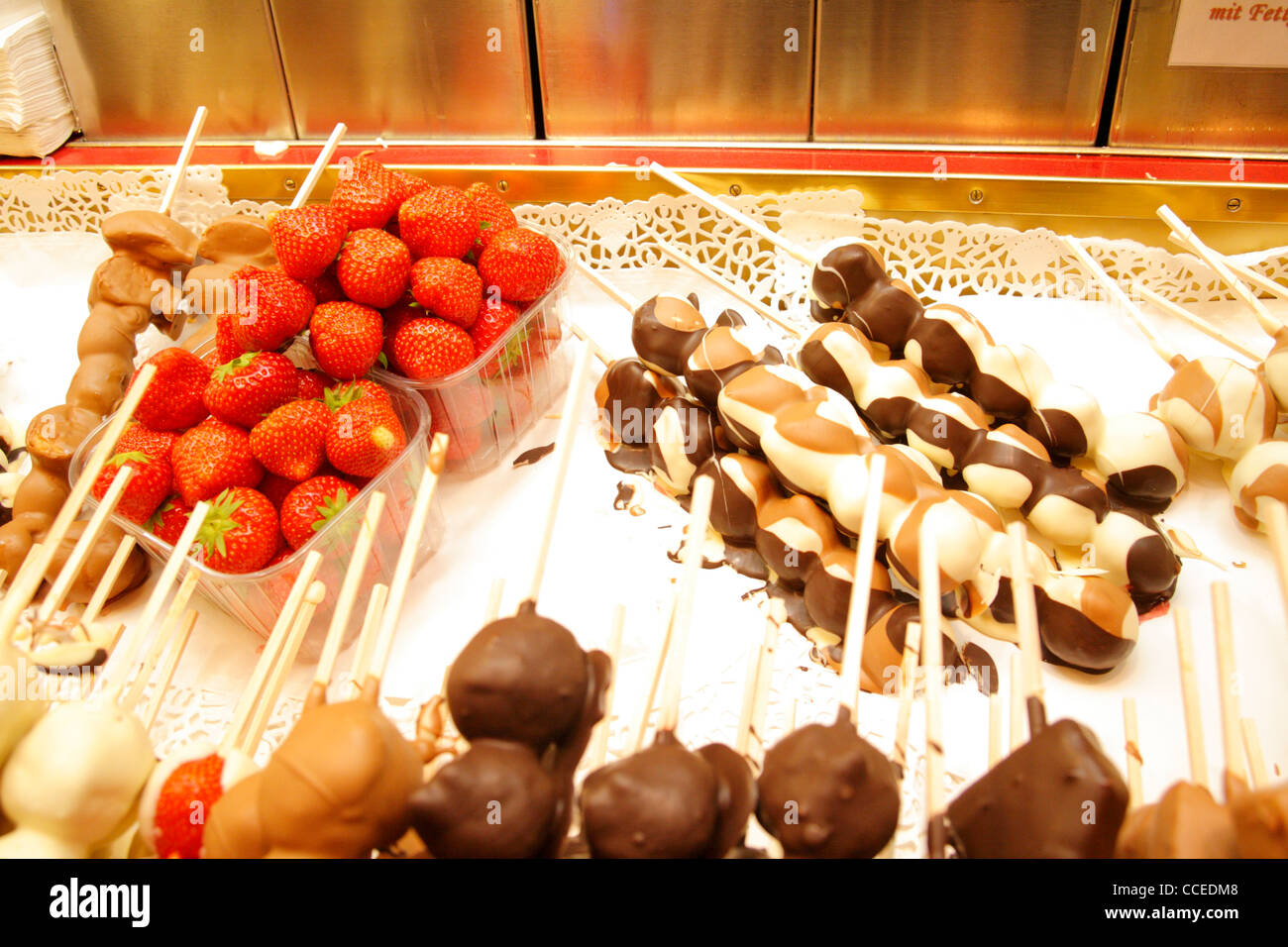 close up of bowls of strawberries, candy and sweets on shelf at german ...