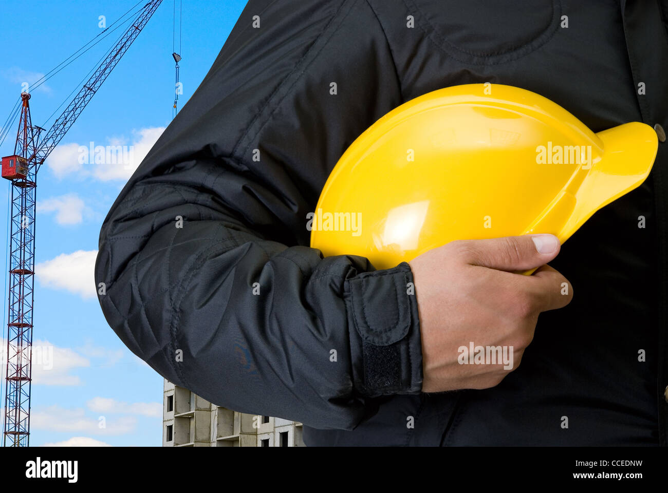 Closeup of yellow helmet at builder hands on building background Stock ...
