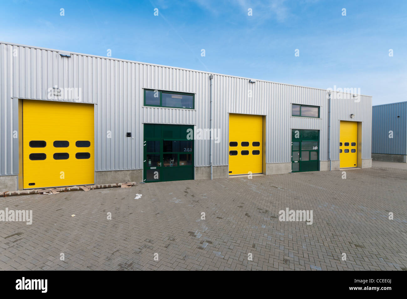 industrial warehouse with yellow and green roller doors Stock Photo - Alamy