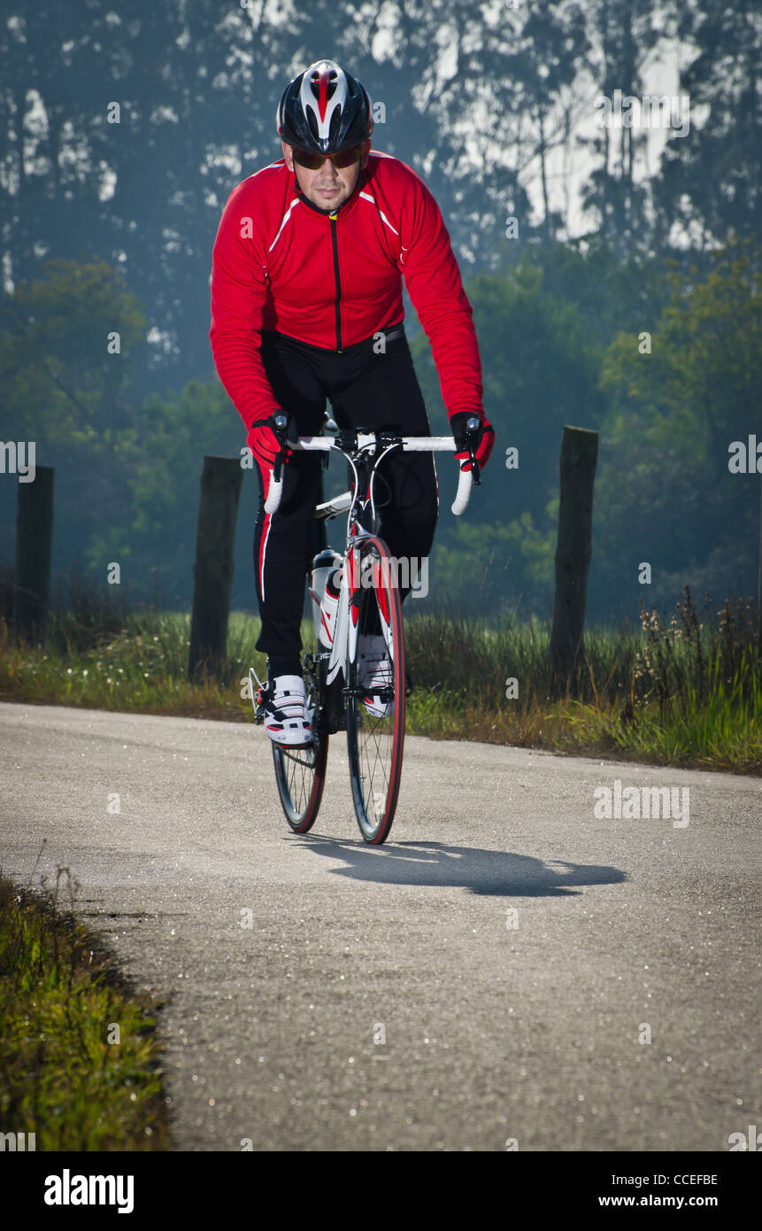Man on road bike riding down open country road Stock Photo - Alamy