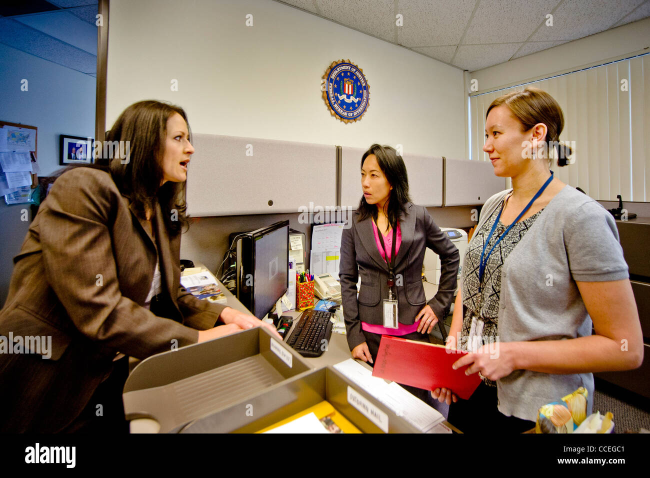 Three female FBI agents discuss a case in Santa Ana, CA, office. Note ...