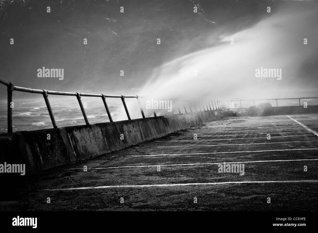 Stormy weather causes waves and spray to crash over car park wall in ...