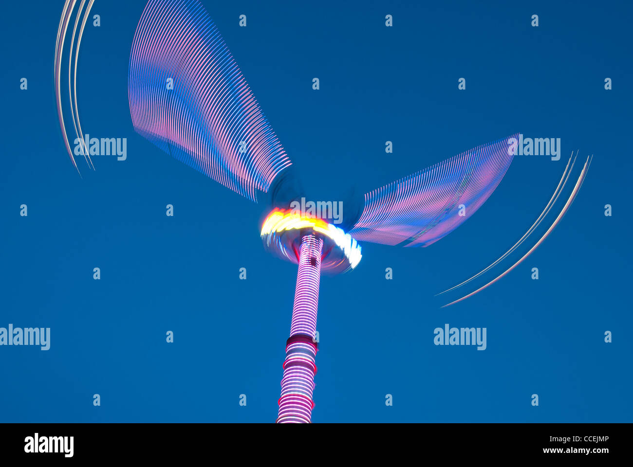 Spinning fairground thrill ride by night Stock Photo - Alamy