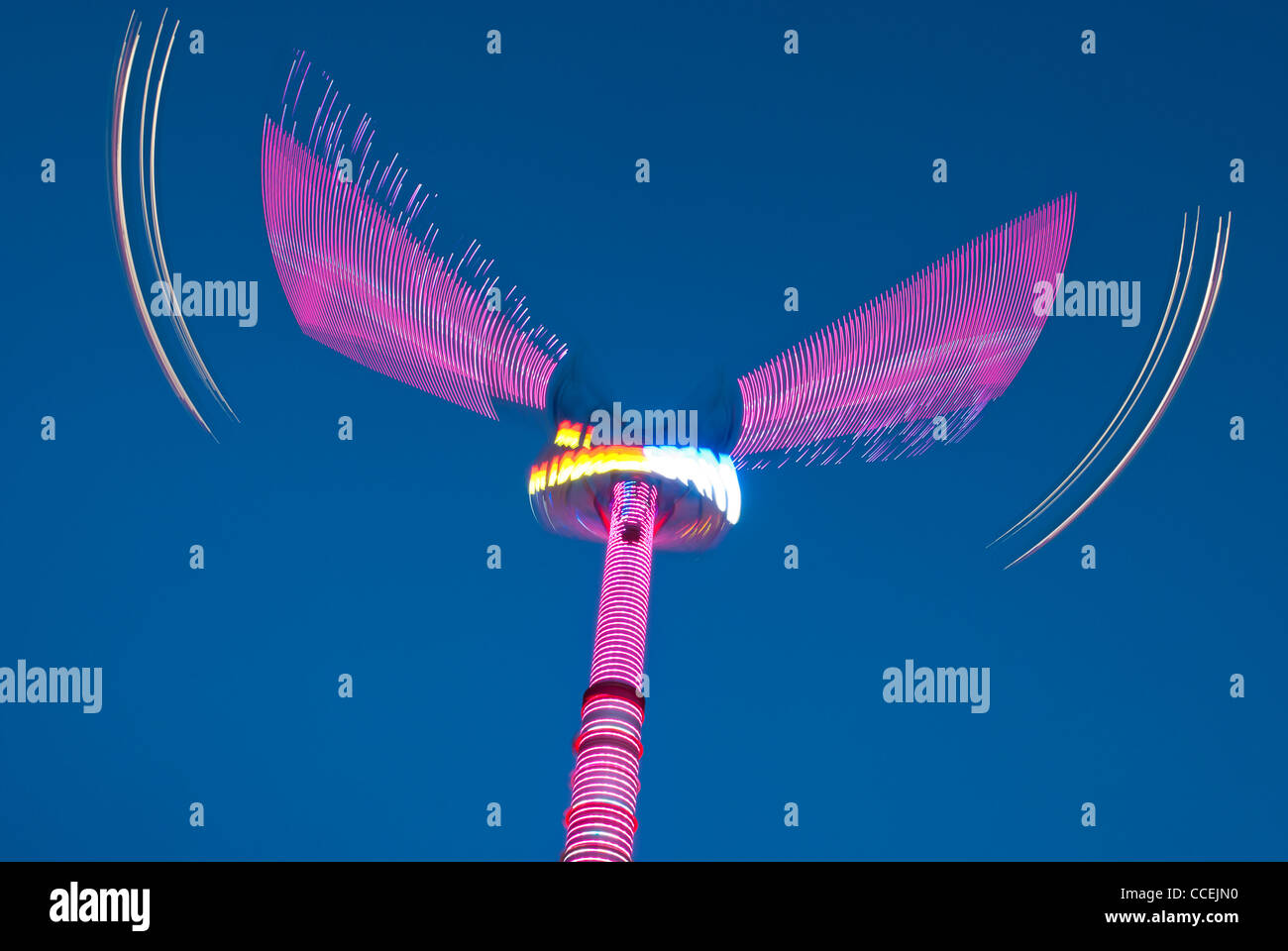 Spinning fairground thrill ride by night Stock Photo - Alamy