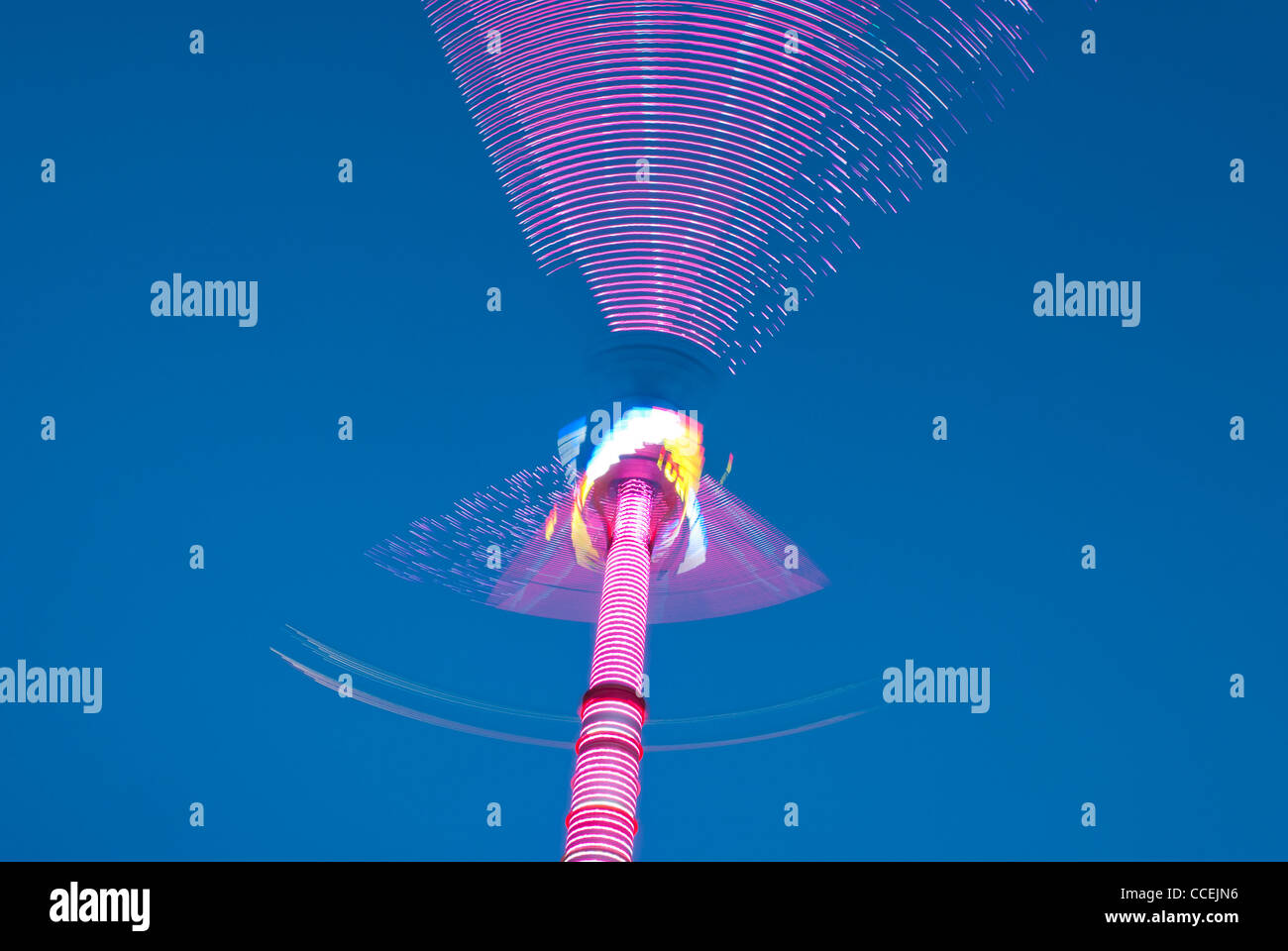 Spinning fairground thrill ride by night Stock Photo - Alamy