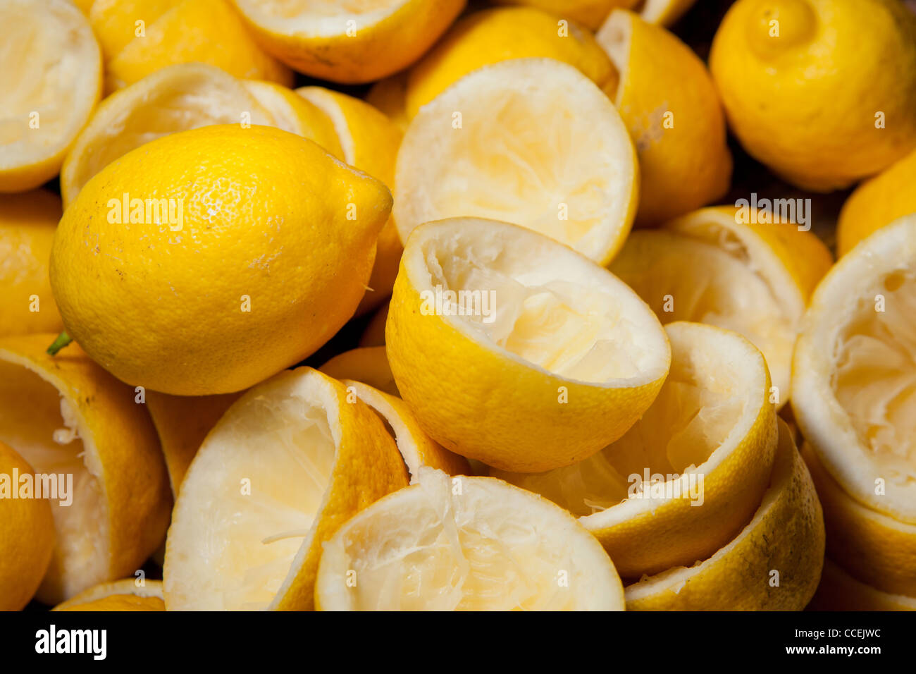 Lots of squeezed lemons in pile with whole lemon after squeezing lemon ...