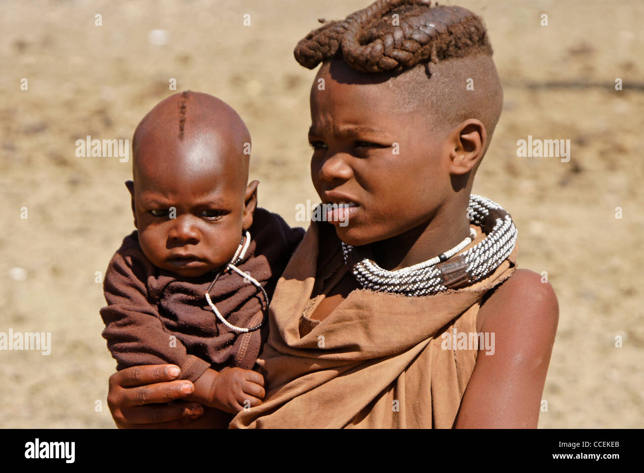 Himba girl with baby brother, village near Opuwo, Namibia Stock Photo ...