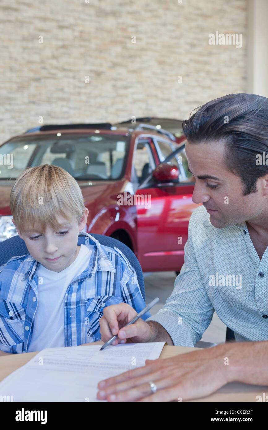 Father with his child signing documents of car Stock Photo - Alamy