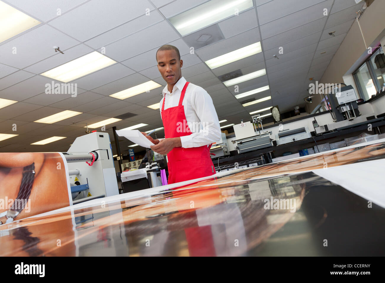 Manual worker looking down at prints Stock Photo - Alamy
