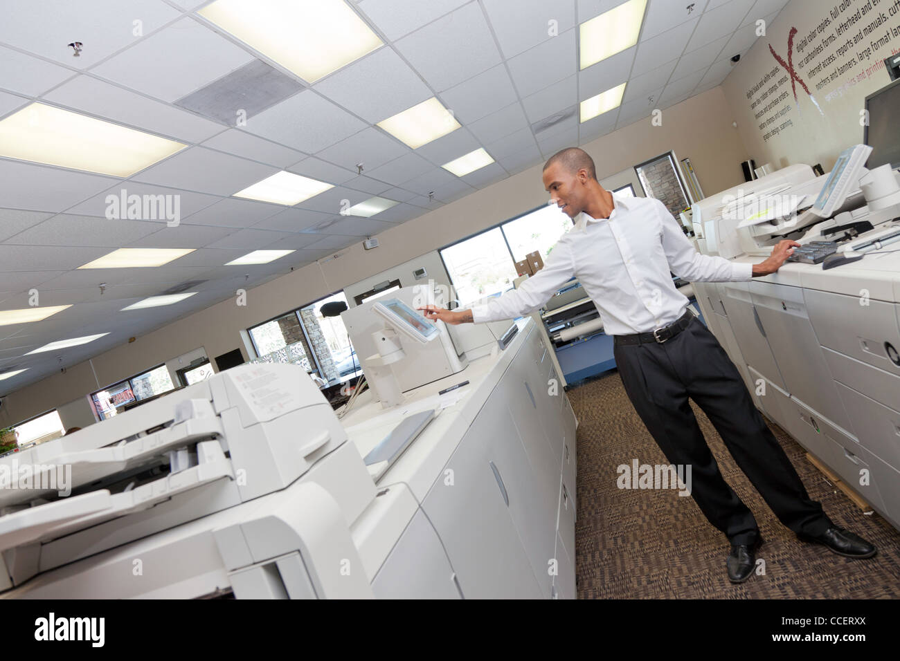 Man working in printing press between two cash register machine Stock ...