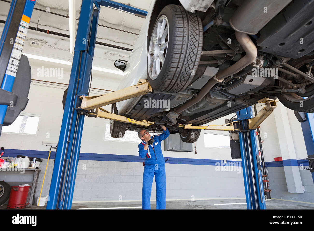 Low angle view of mechanic working under car Stock Photo - Alamy