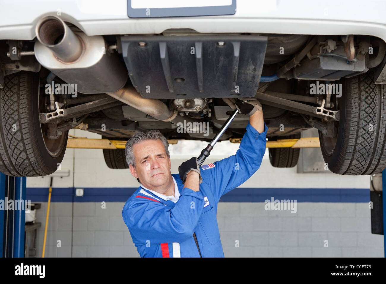 Portrait of mechanic working under car Stock Photo - Alamy