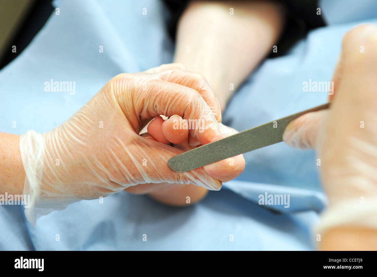 A chiropodist treats a patient's foot by filing the toenails Stock ...
