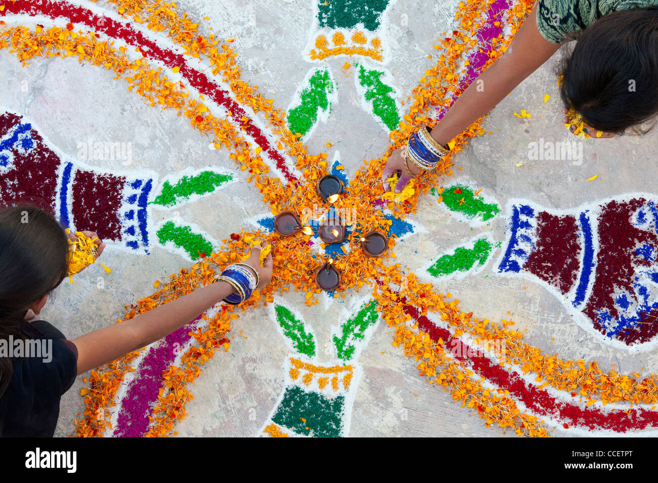 India sisters making a Rangoli design at Sankranthi festival ...