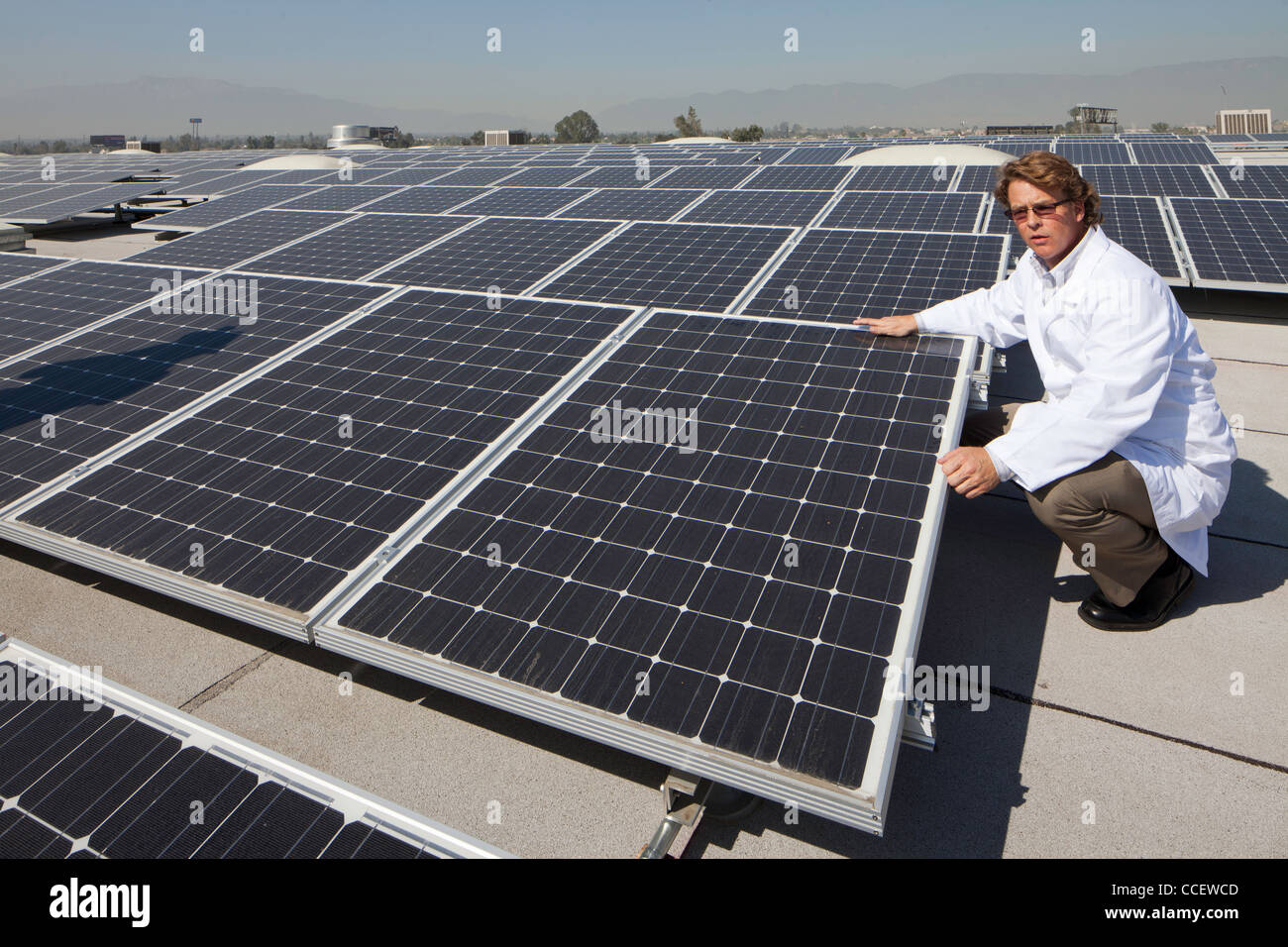 Factory worker sitting besides solar panels Stock Photo - Alamy