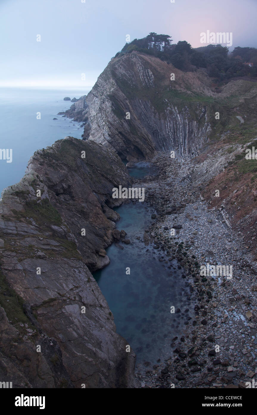 Looking down from the clifftop into Stair Hole. The tilted rock strata ...