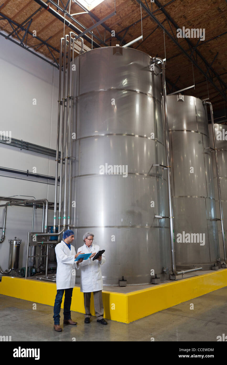 Full-length of factory workers having discussion at bottling plant ...