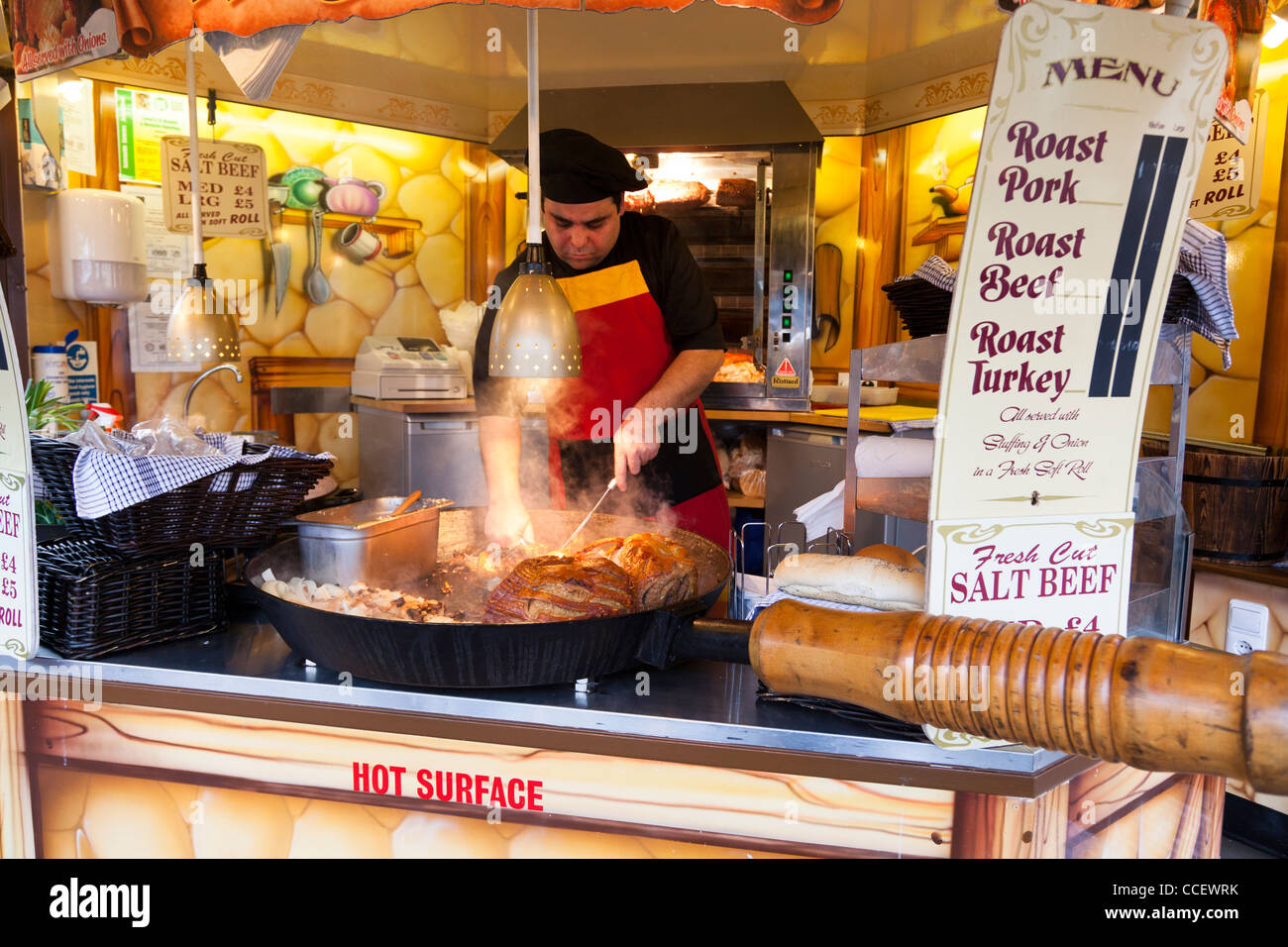Man cook meat dishes in a large frying pan on an outdoor stall Stock ...