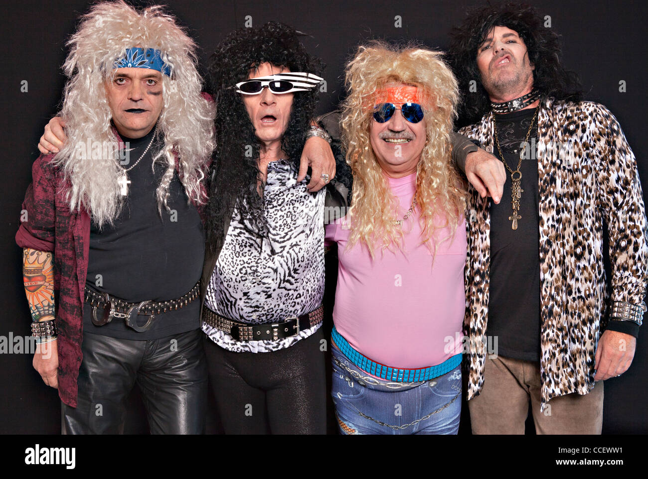 Portrait of rock musicians standing with arms on shoulders over black ...