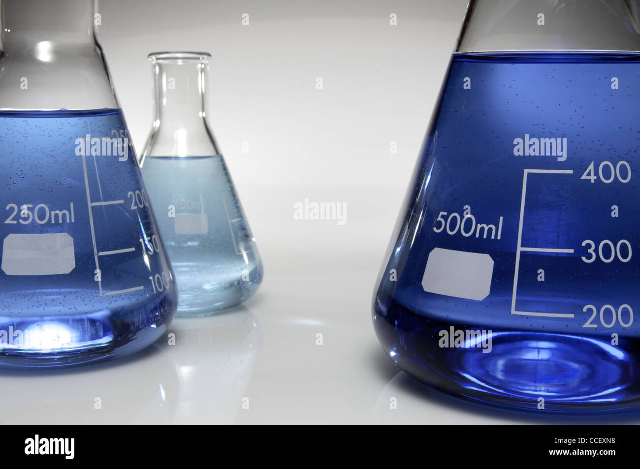 three conical flasks with liquid blue and white background Stock Photo ...