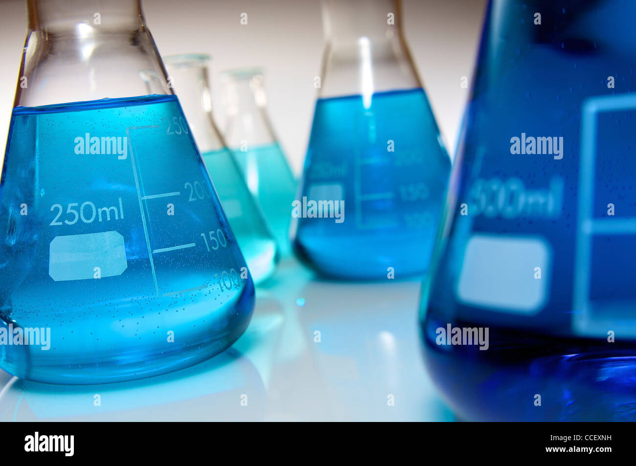 group of glass flasks with blue liquid in a laboratory Stock Photo - Alamy